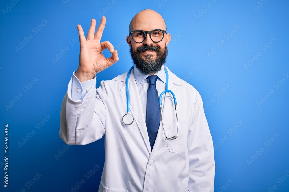Handsome bald doctor man with beard wearing glasses and stethoscope ...