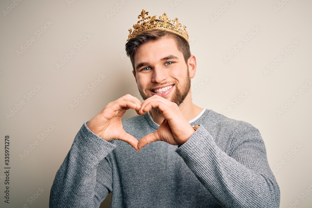 Young blond man with beard and blue eyes wearing golden crown of king ...