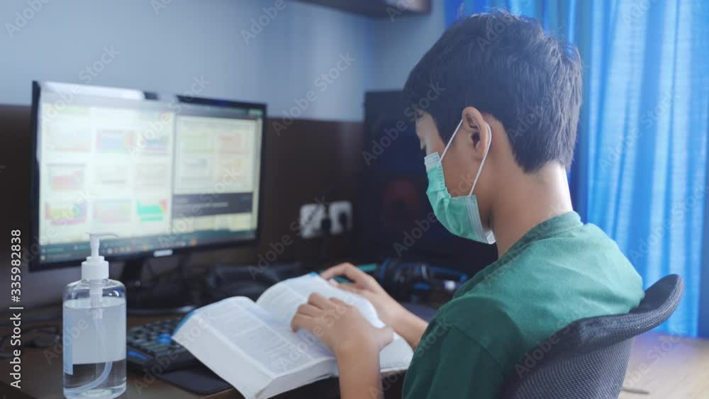Preteen boy using a computer and studying at home Stock Video | Adobe Stock