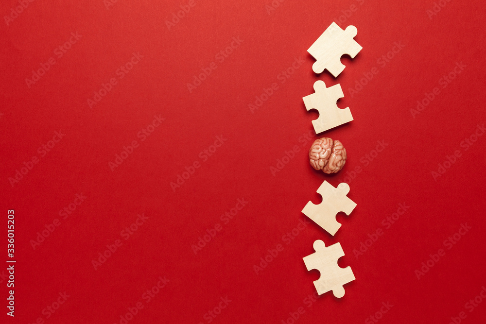 Human brain with a puzzle on red background. Business idea, memory loss ...
