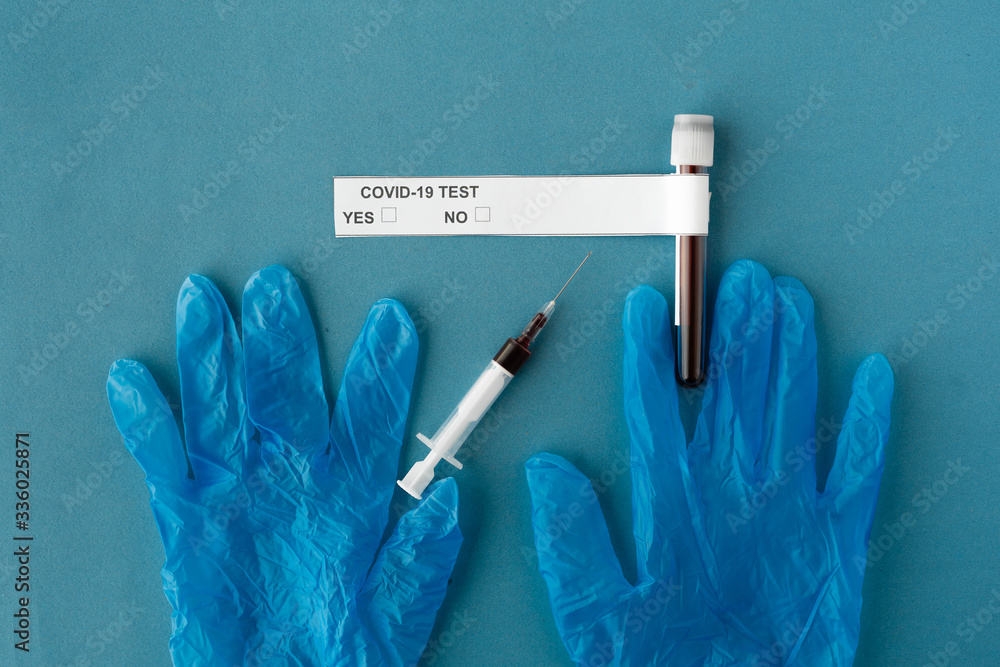 on a blue background medical gloves a syringe with analyzes and a test ...