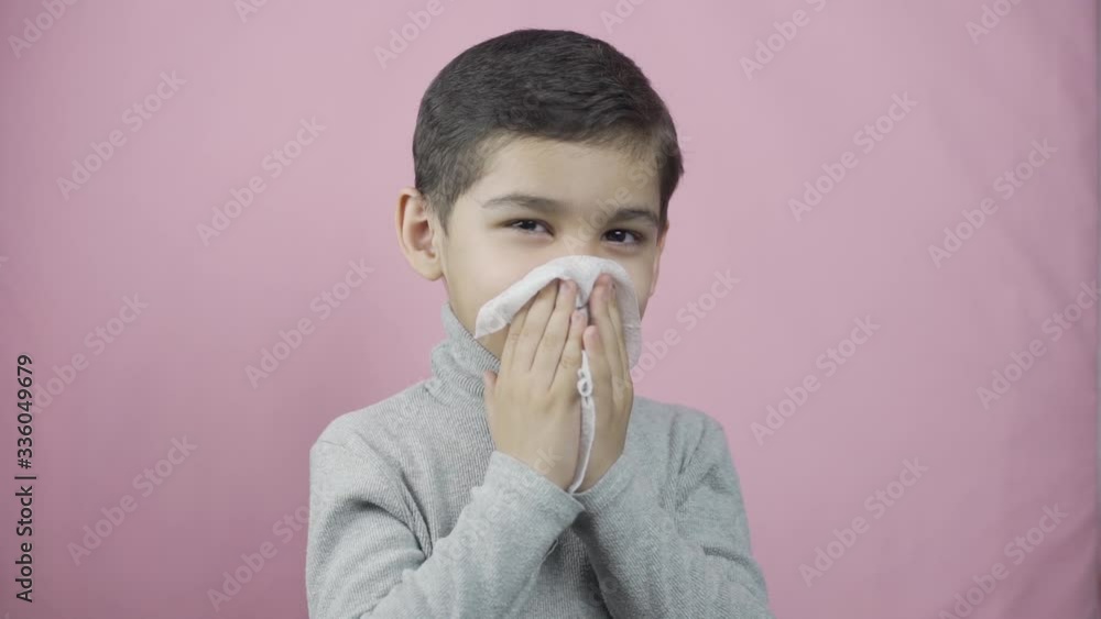 A pre-school kid with flu virus wiping his nose with a napkin. Little ...