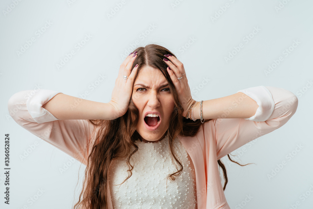 long-haired beautiful brunette girl angry and holding his head isolated ...