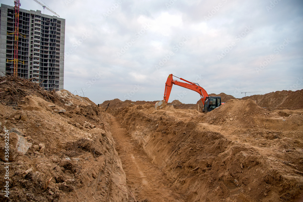 Excavator digg trench for laying sewer pipes and main reticulation ...