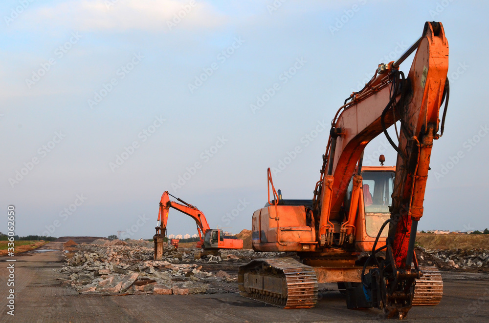 Excavator with hydraulic breaker hammer at construction site ...