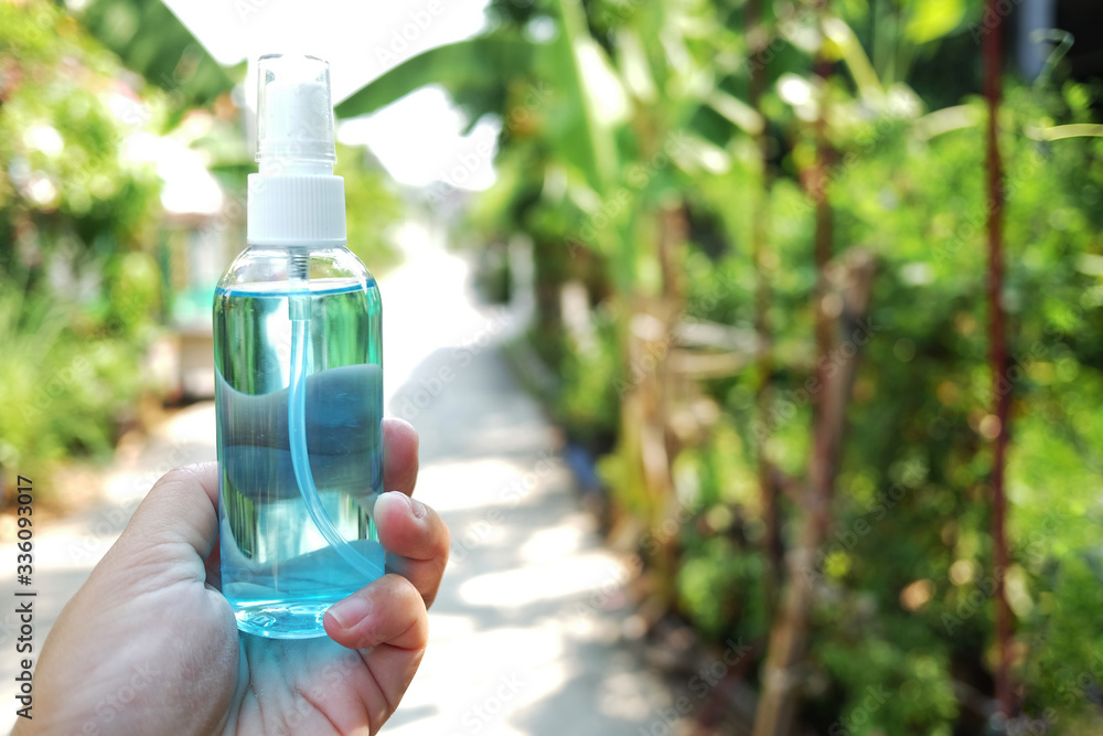 Hand holding a bottle of Ethanol or ethyl alcohol spray for based hand ...