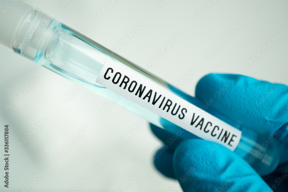scientist holding test tube with covid-19 or coronavirus vaccine label ...