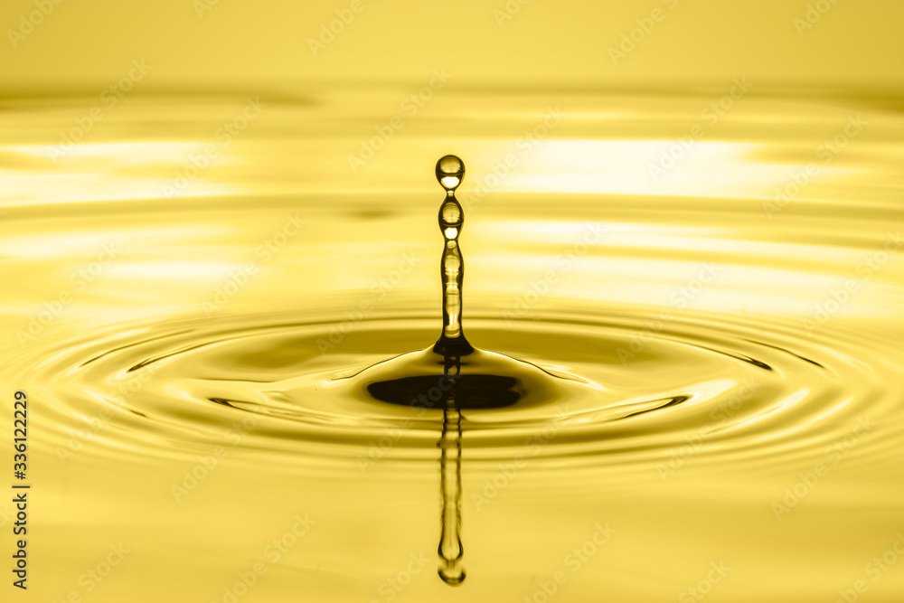 Drop of Vegetable oil or engine oil water and ripple on golden ...