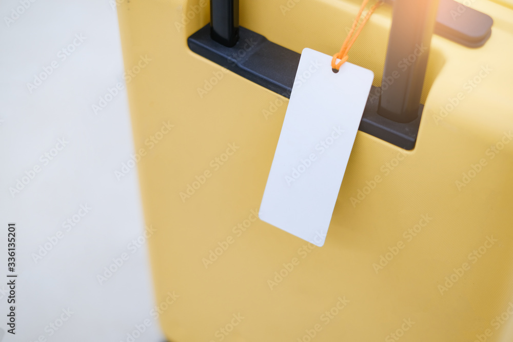 Close up mock up brand tag or name tag tied to yellow thick suitcase ...