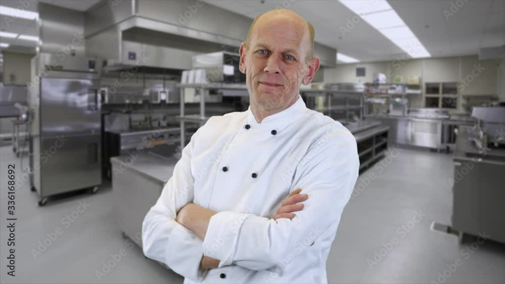 An happy executive head chef of a restaurant turns and smiles. The ...