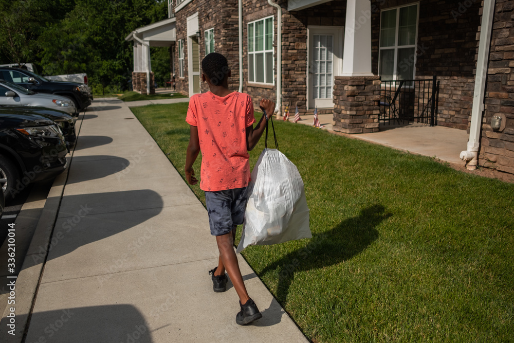 Pre Teen taking out garbage Stock Photo | Adobe Stock