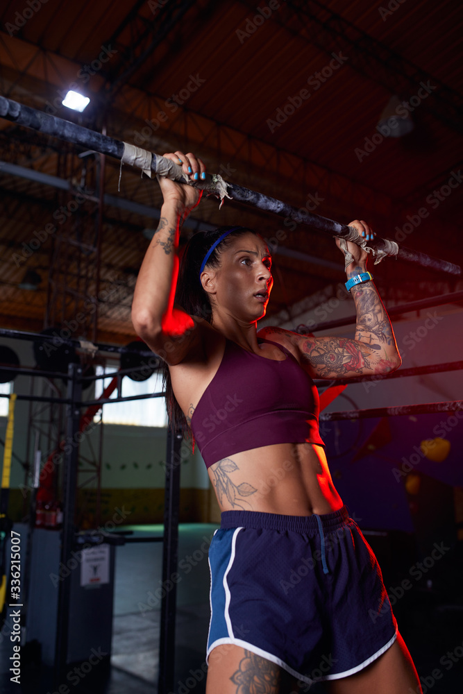 Strong female doing pull ups. Stock Photo | Adobe Stock