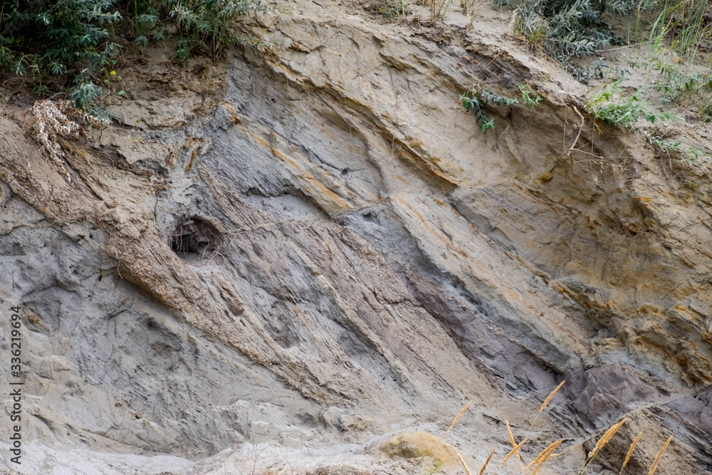 sedimentary layers of the rock in the sand scree. sand, pebbles and ...