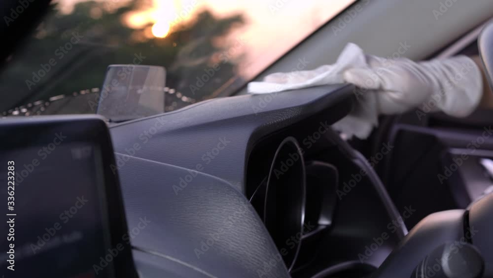 white glove hand spraying and wipe car interior console panel ...
