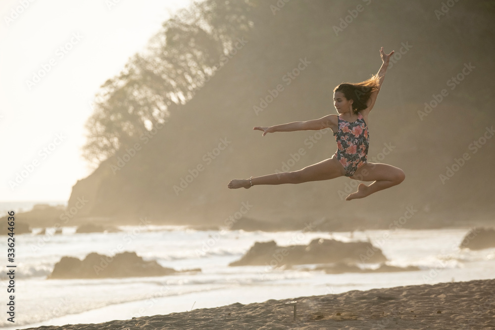 Teenage girl practicing gymnastic at seafront by sunset, Jaco Beach ...