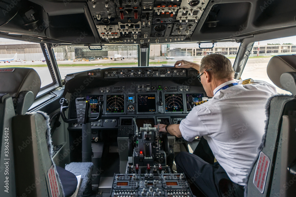 Pilot in the cockpit of a passenger plane preparing aircraft for take ...