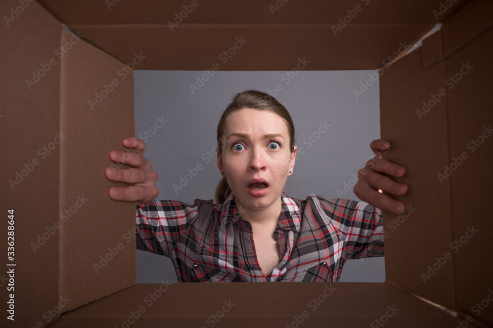 The girl emotionally looks through the box, fees for moving, emotions ...