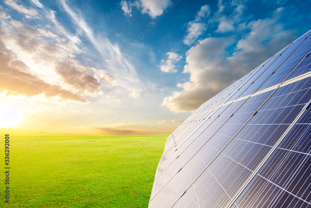Photovoltaic solar panels and green grass on sky background,green clean ...