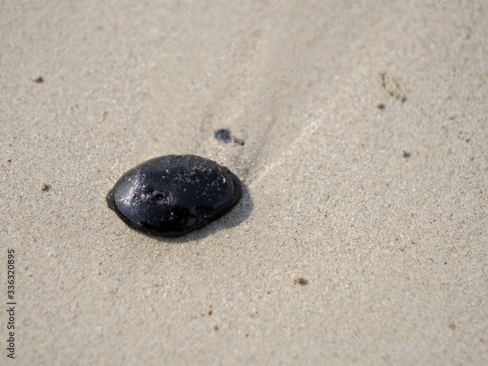 Close up of a tar ball / tar patty on a beach on Bintan island Stock ...