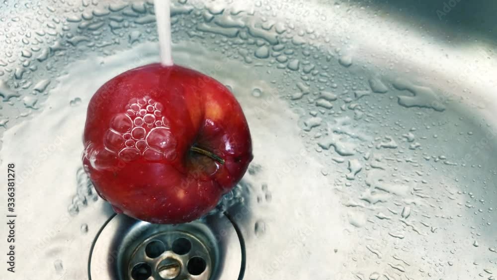 Sanitize raw food & fruits.Red ripe apple washing in kitchen sink. in ...