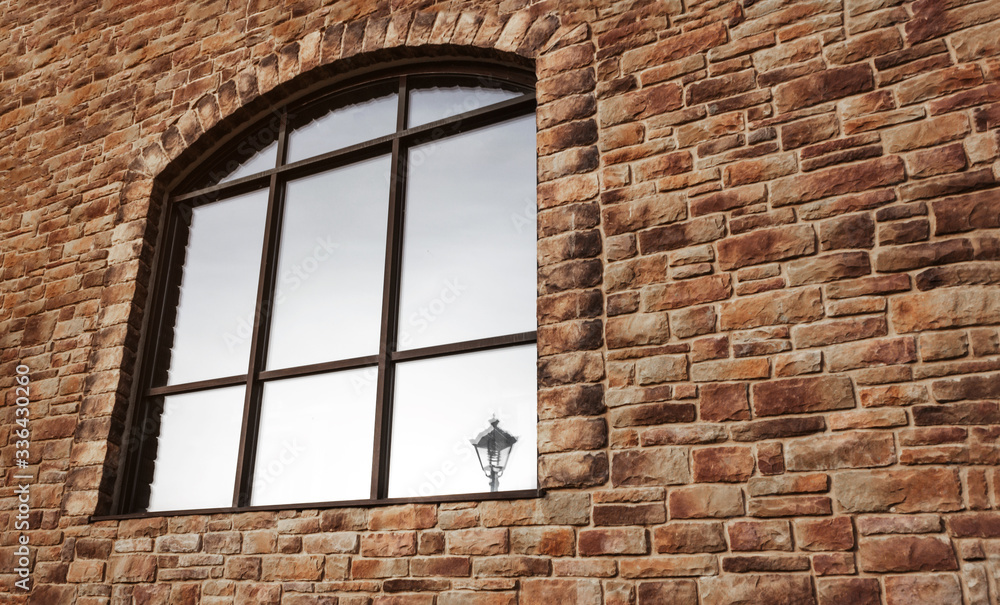 large arch-shaped window with binding and reflection of a lantern in ...