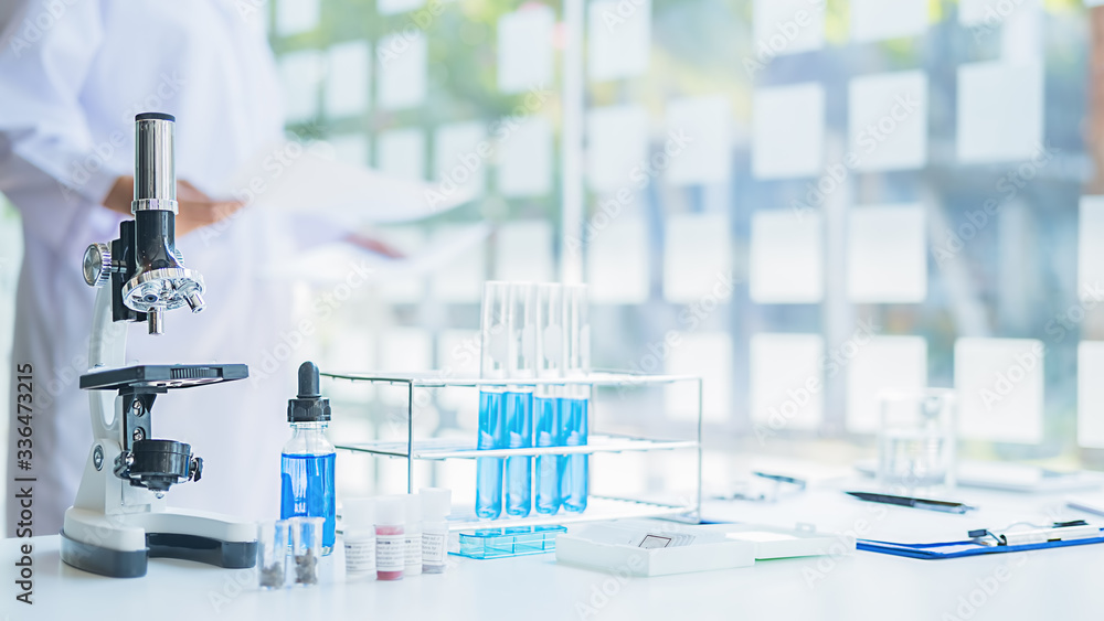 Medical or scientific researcher or man doctor looking at a test tube ...