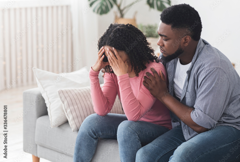 Caring black boyfriend comforting his upset crying girlfriend at home ...