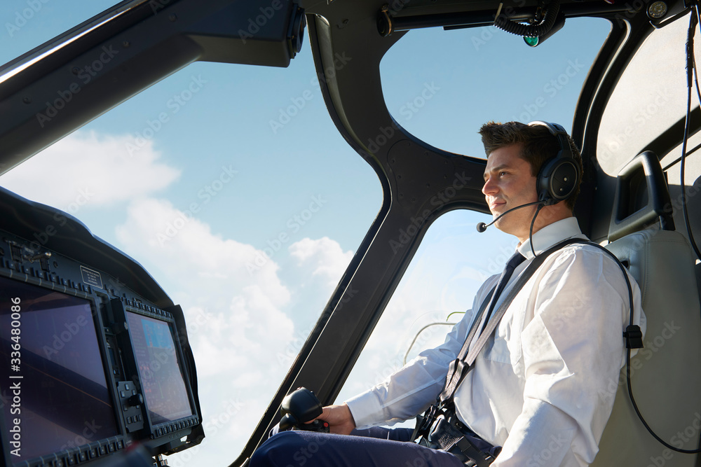 Male Pilot In Cockpit Of Helicopter During Flight Stock Photo | Adobe Stock