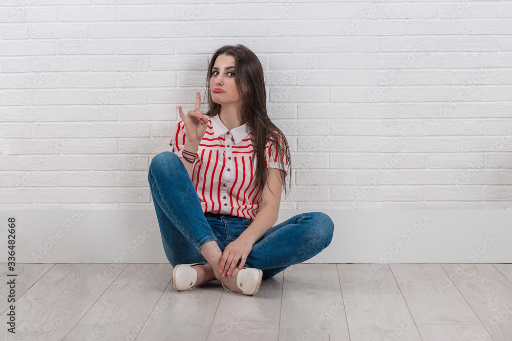 You rock. Funny girl sat cross-legged on floor, showing heavy metal ...
