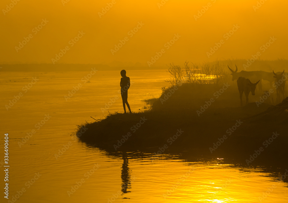 Mundari tribe child on the bank of river Nile at sunset, Central ...