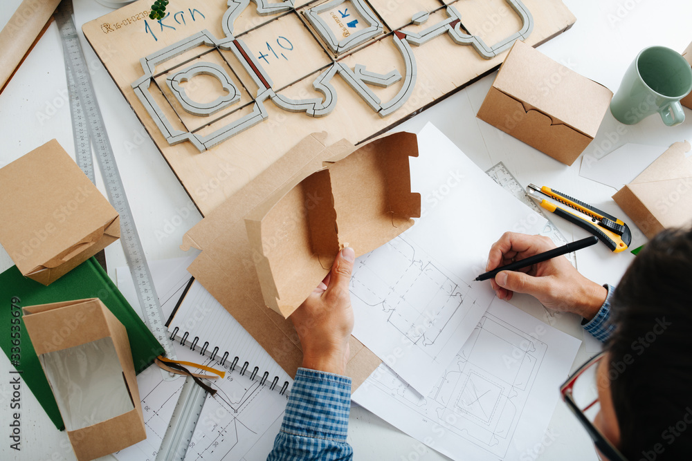 Box maker looking at box, drawing it's schematics Stock Photo | Adobe Stock