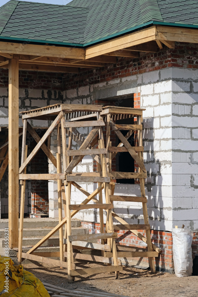 Small wooden scaffolding near the wall during the day, without people ...