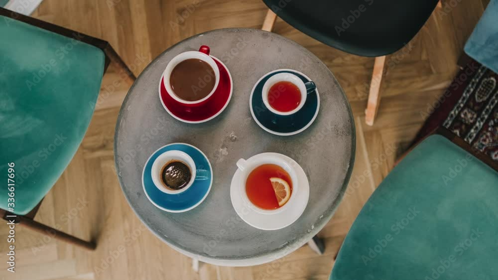 stop motion animation, cups with tea and coffee spin on a round ...