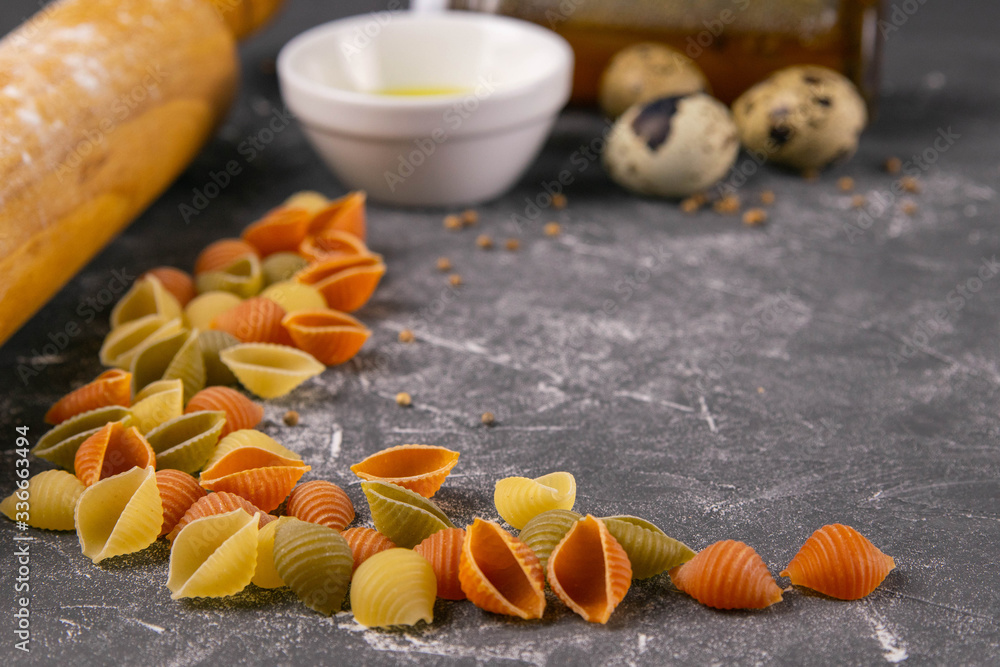 Pasta Conchiglie Rigate, mix of colorful uncooked shells with rocking ...