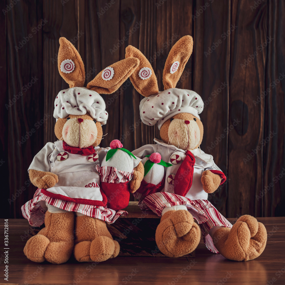 Handmade couple of cooker plush rabbits on a woody background Stock ...