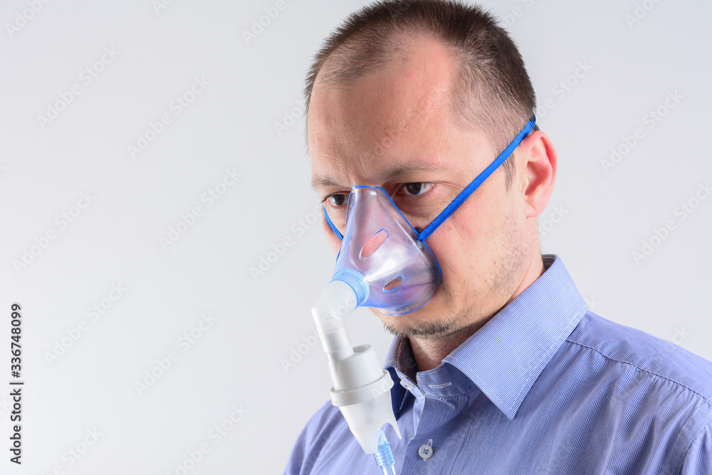 Man Inhaling Through Inhaler Mask. Portrait of man wearing an ...