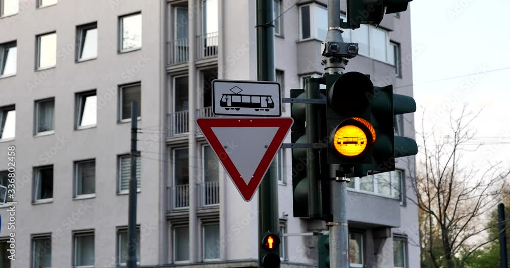 Blinking warning amber traffic light with warning sign of light rail ...