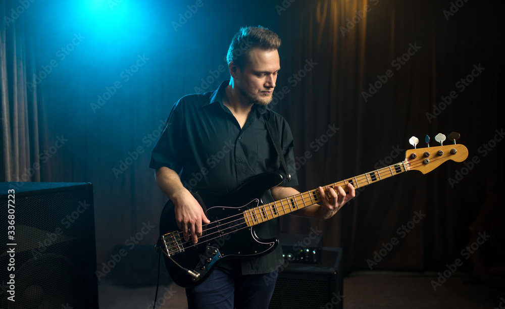 Male guitarist playing an electric bass guitar Stock Photo | Adobe Stock