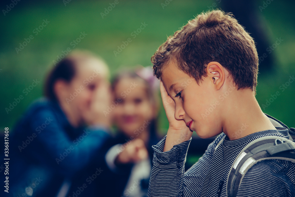 Little sad boy feeling left out, teased and bullied by his classmates ...