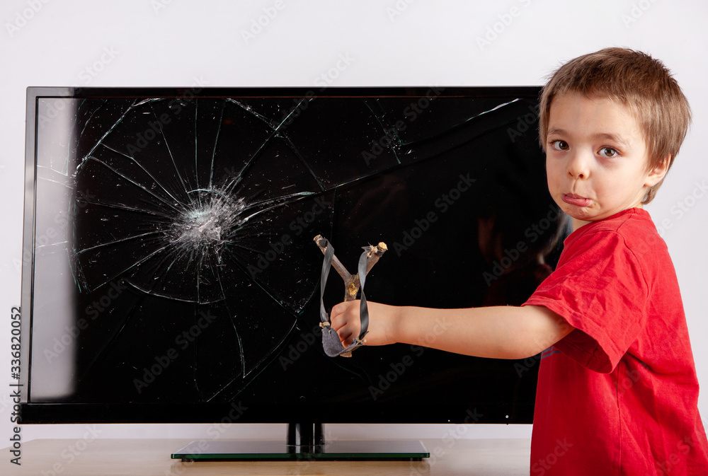 Poster Shocked little boy standing in front of a TV with broken screen ...