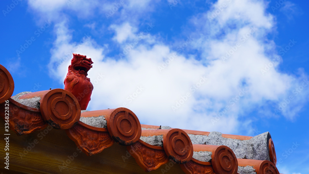 Sculpture of the mythical shisa on the roof. clay statuette on a ...