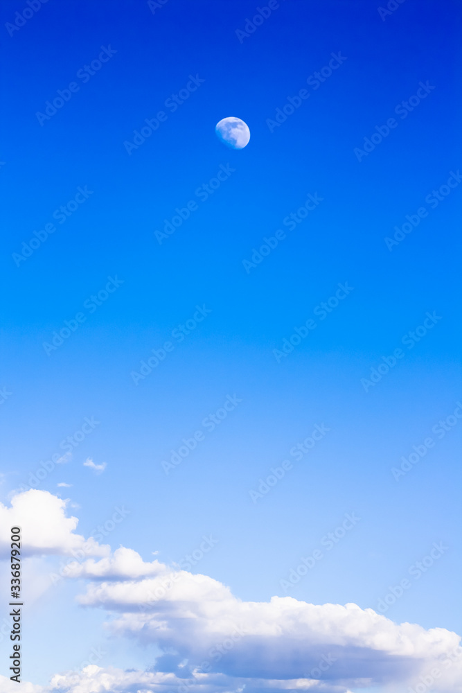 Blue gradient sky with moon and clouds. Vertical background with ...