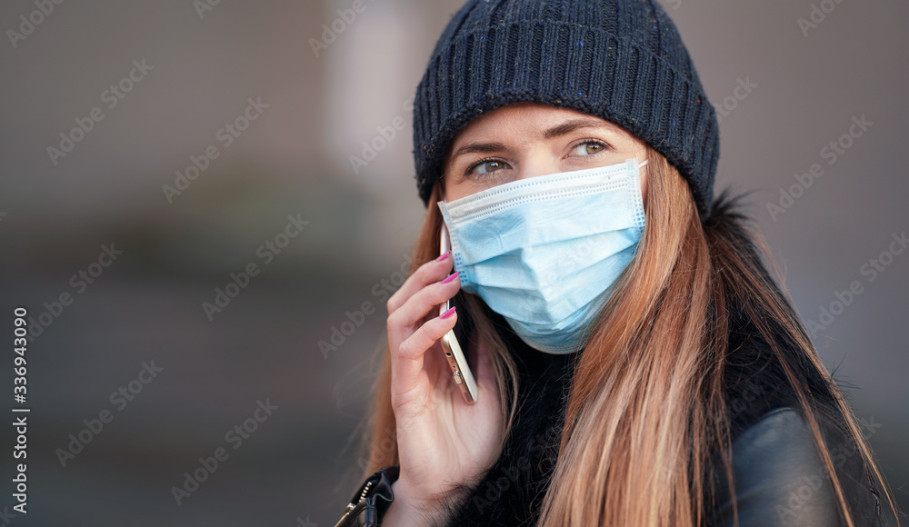 Young woman wearing disposable blue virus face mouth nose mask talking ...