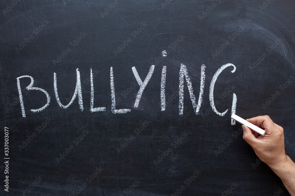 Bullying word handwritten on a chalkboard. Hand with chalk Stock Photo ...