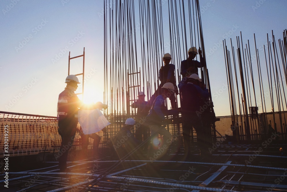 The construction of a rooftop high rise building, workers are tied with ...
