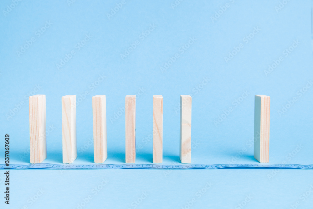 wooden dominoes stand in a row on a blue background, one block is ...