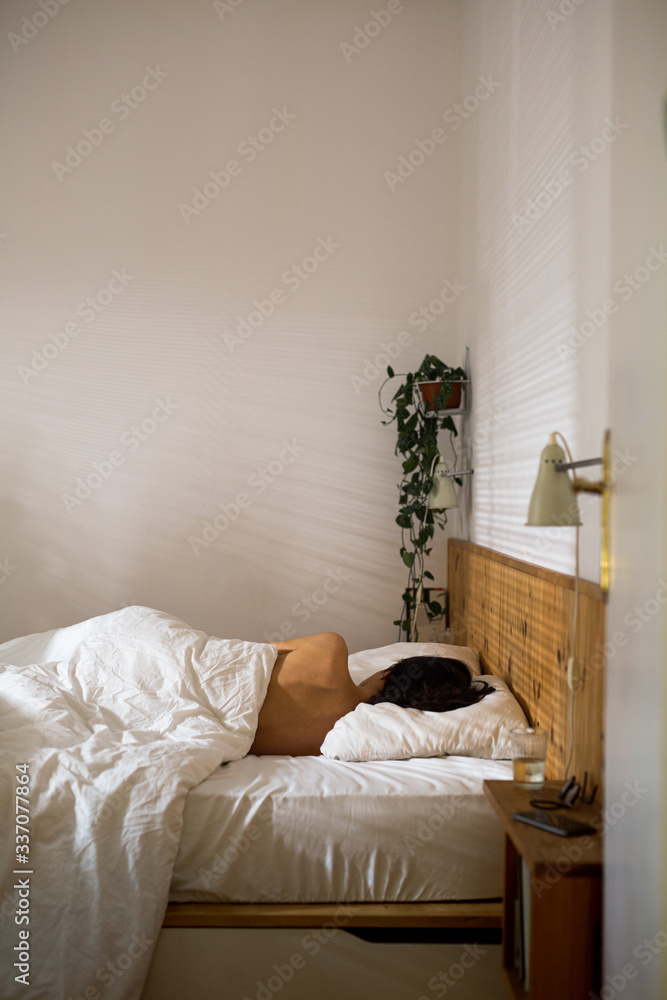 Back view of young woman sleeping on a bed. Stock Photo | Adobe Stock