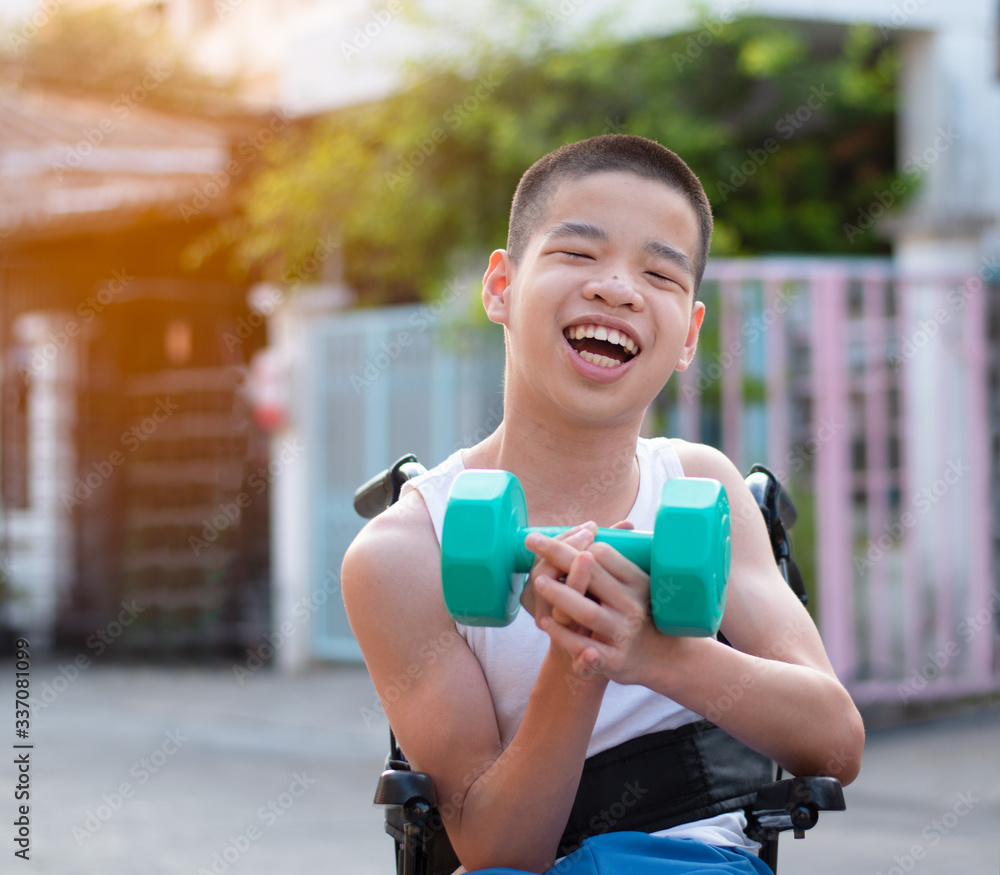 Disabled child on wheelchair is lifting dumbbells to strengthen muscles ...