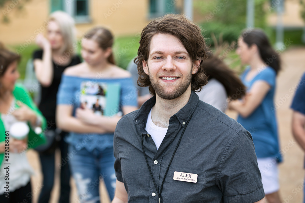 Tour: Smiling Tour Guide With Group Behind Stock Photo | Adobe Stock
