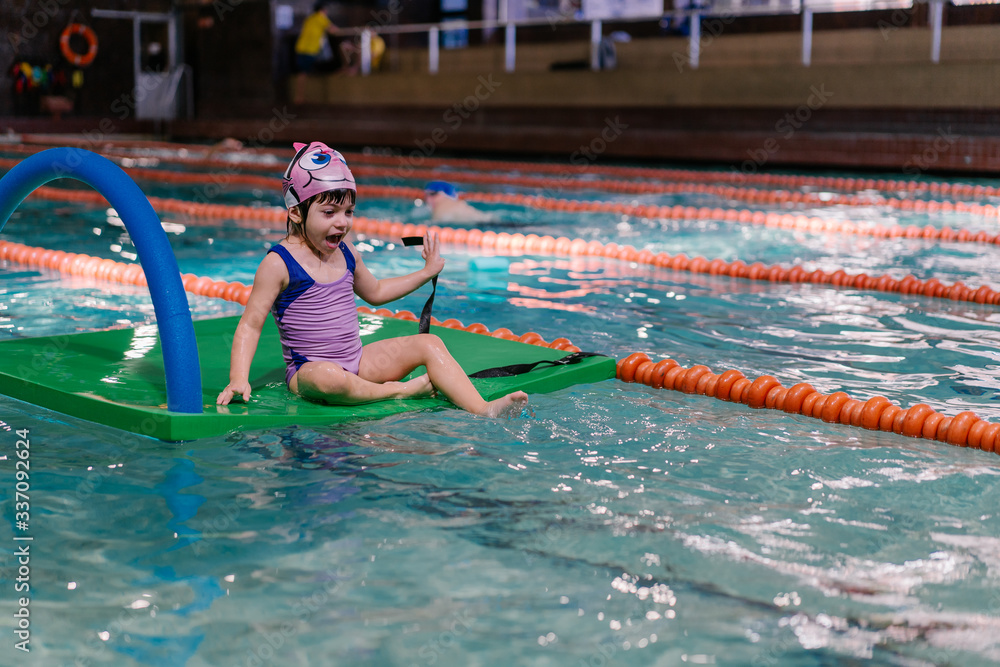 Little Girl Swimming In A Indoor Pool. Stock Photo | Adobe Stock
